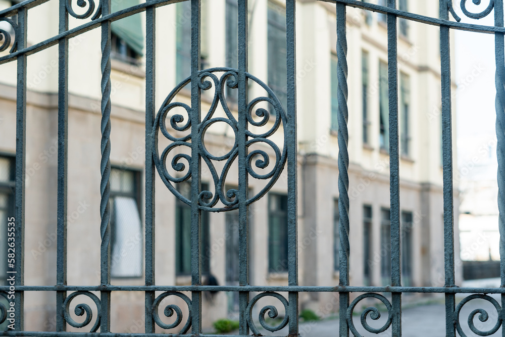 A large, wrought iron gate with a handrail stands as a secure barrier ...