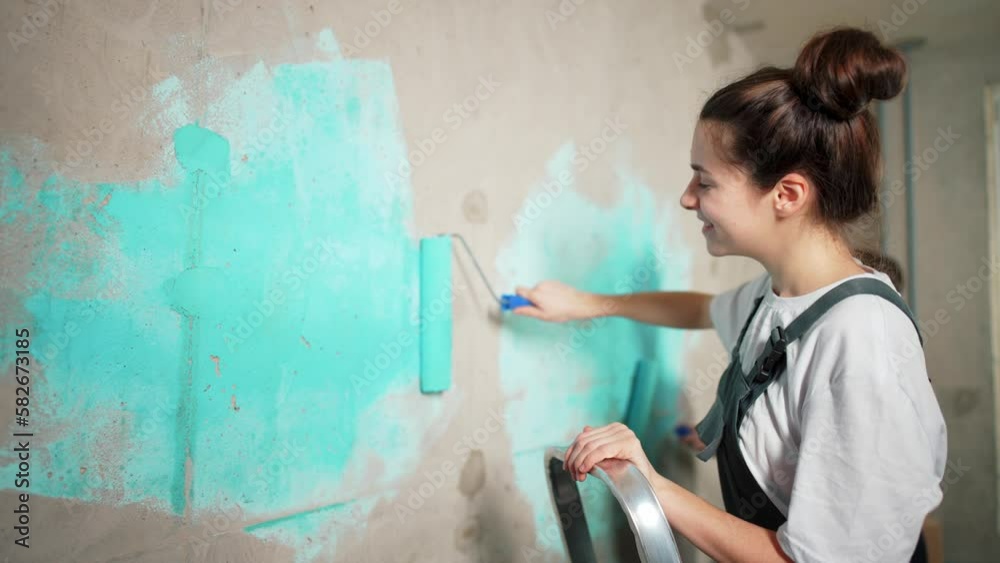 Happy family couple together painting and priming wall with painting ...