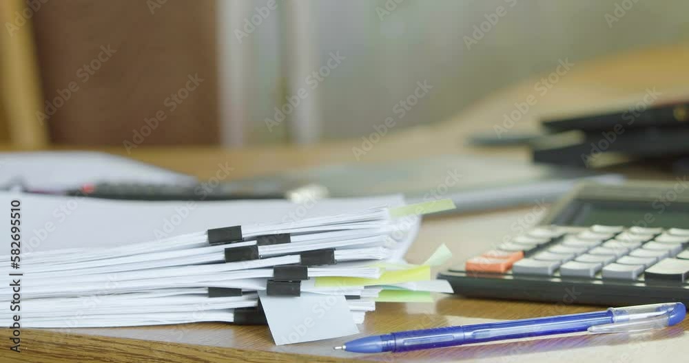 Human putting a stack of sheets on a desk at the office. A lot of work ...