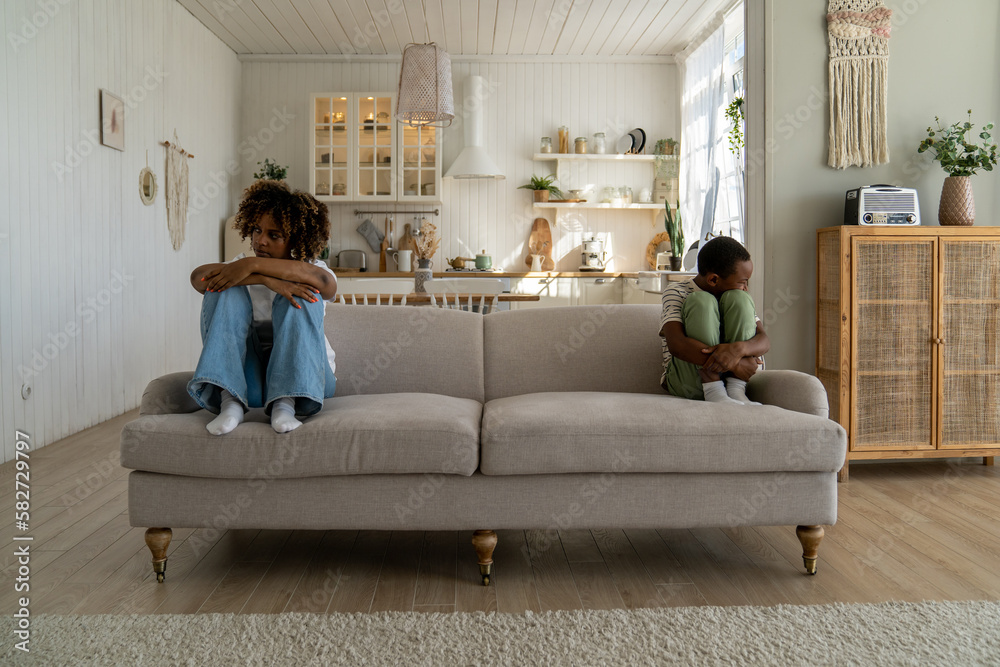 Foto de Upset unhappy African American family mother and son sitting ...