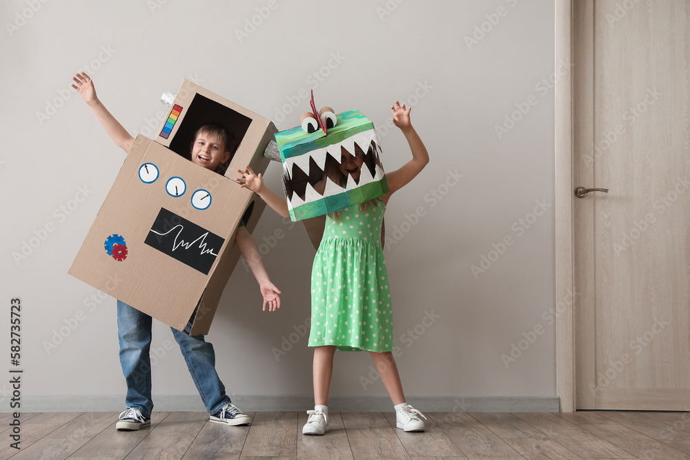 Little children in cardboard costumes playing near light wall Stock ...