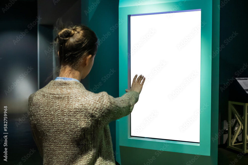 Woman using white blank interactive touchless vertical display of ...