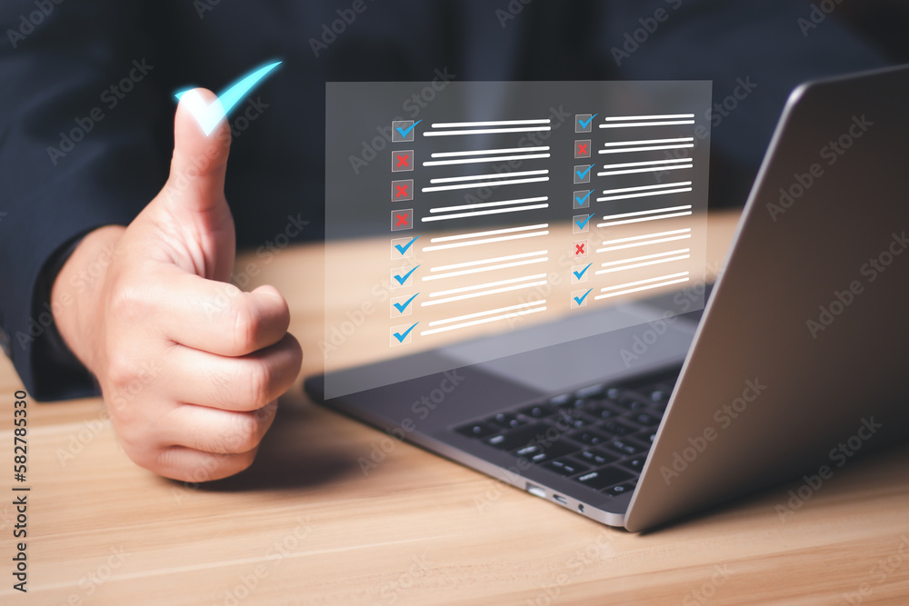 Businessman working on laptop computer productivity checklist and ...