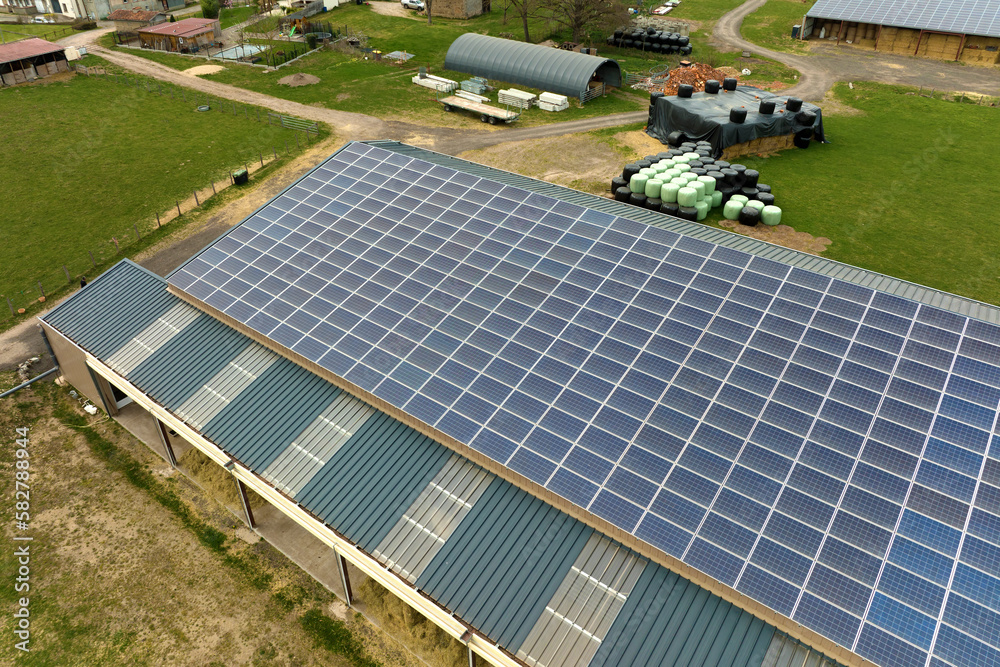 Aerial view of farm building with photovoltaic solar panels mounted on ...