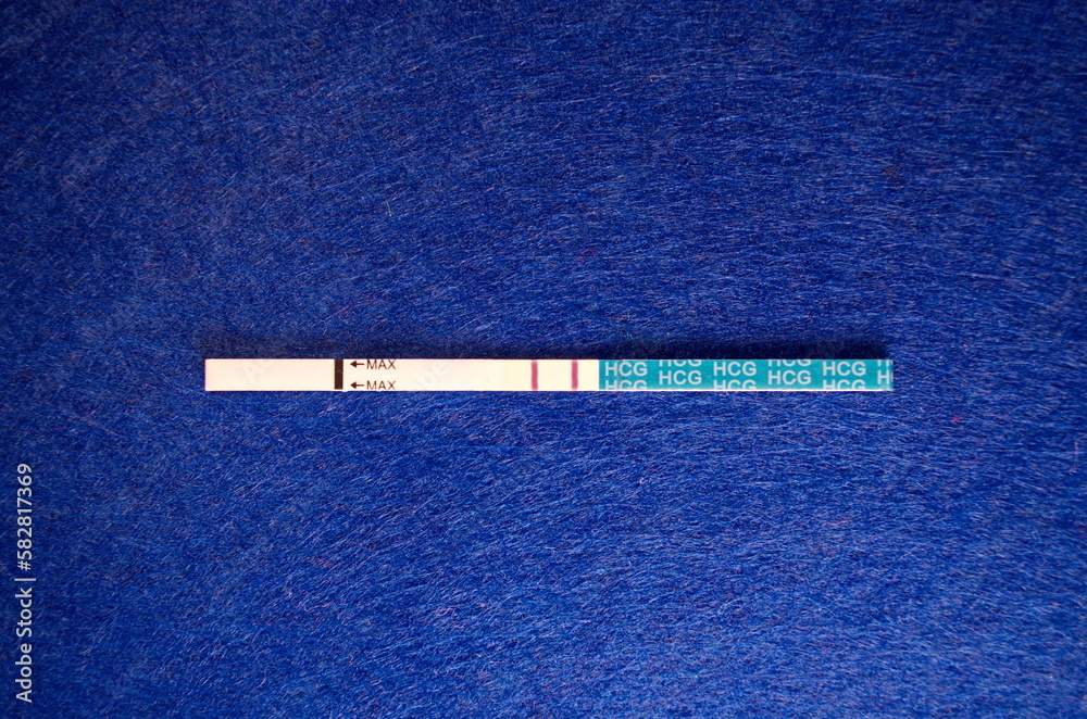 positive stick pregnancy test on blue background. Planning of pregnancy ...