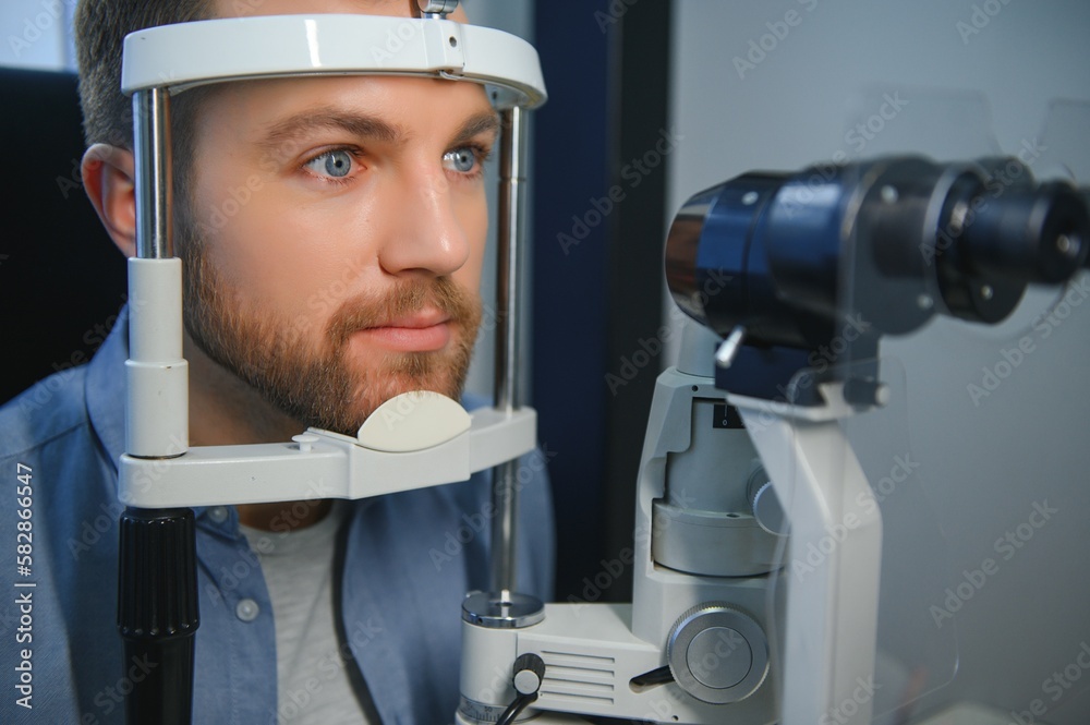 Foto de Handsome young man is checking the eye vision in modern ...