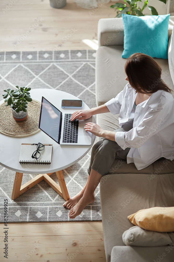 Mockup white screen laptop woman using computer sitting on sofa at home ...