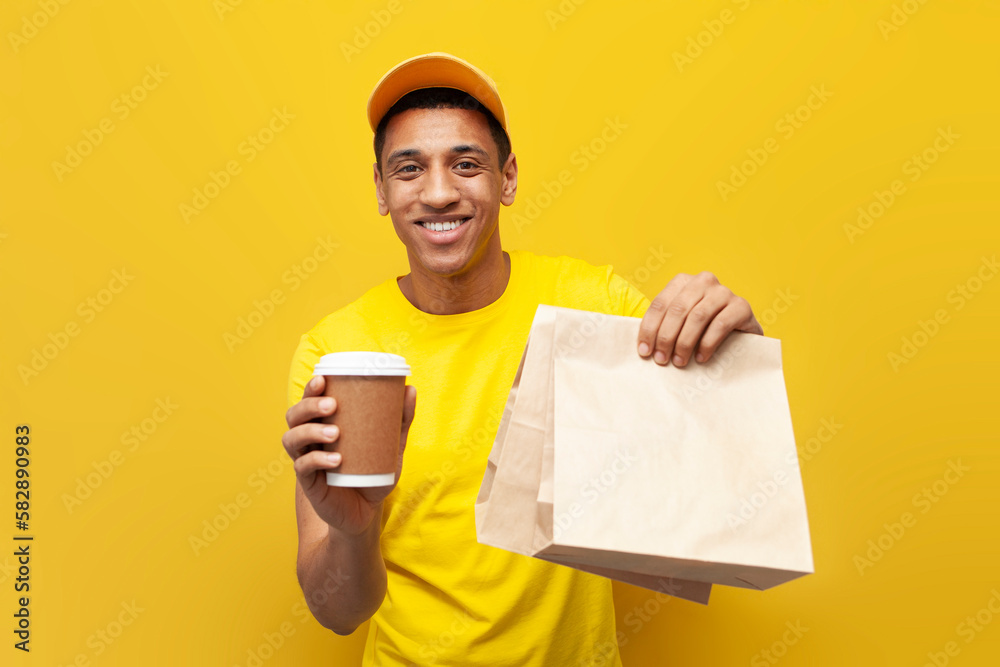 african american delivery man in yellow uniform holds order in package ...