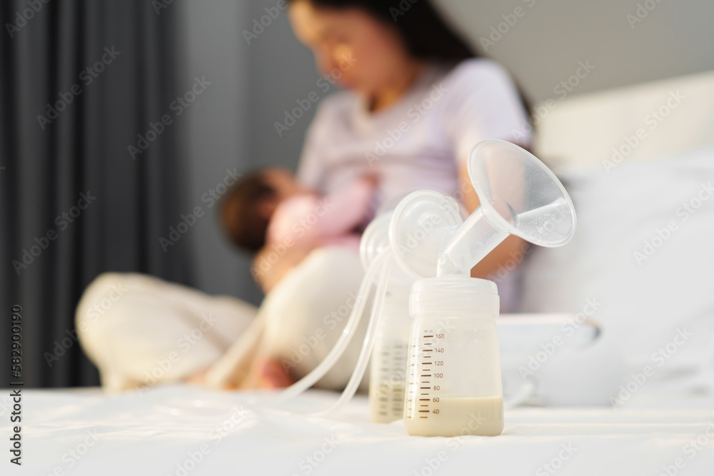 The Breast Milk Are In The Bottles Of Electric Breast Pumping Set On Bed With Mother
