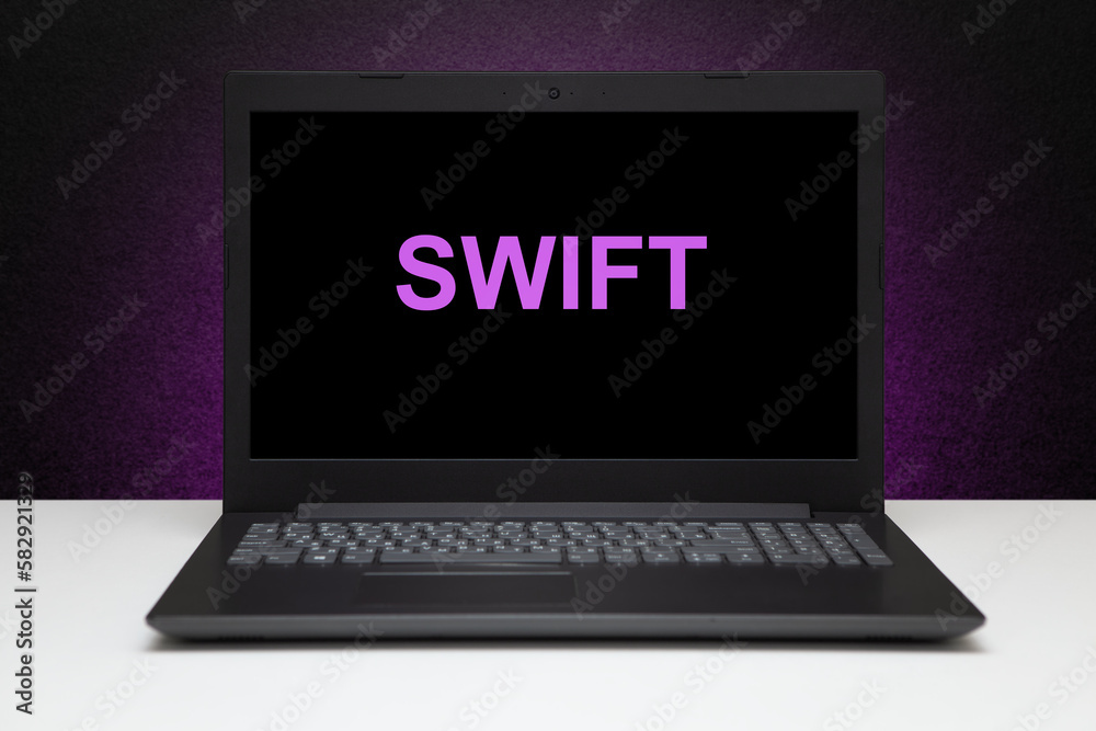 Swift text on laptop screen on textured black background with purple ...