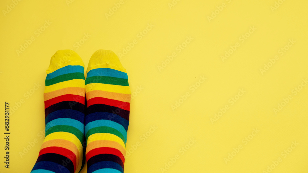 legs in rainbow socks and on a monochrome yellow background, a layout ...