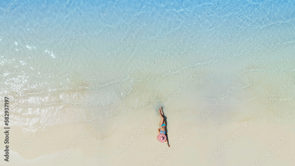 Aerial view with woman in bikini sunbathing as laying on the beach ...