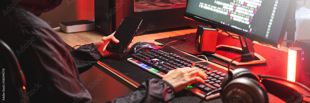 Dangerous Hooded Hacker typing bad data into computer online system and spreading to global ...