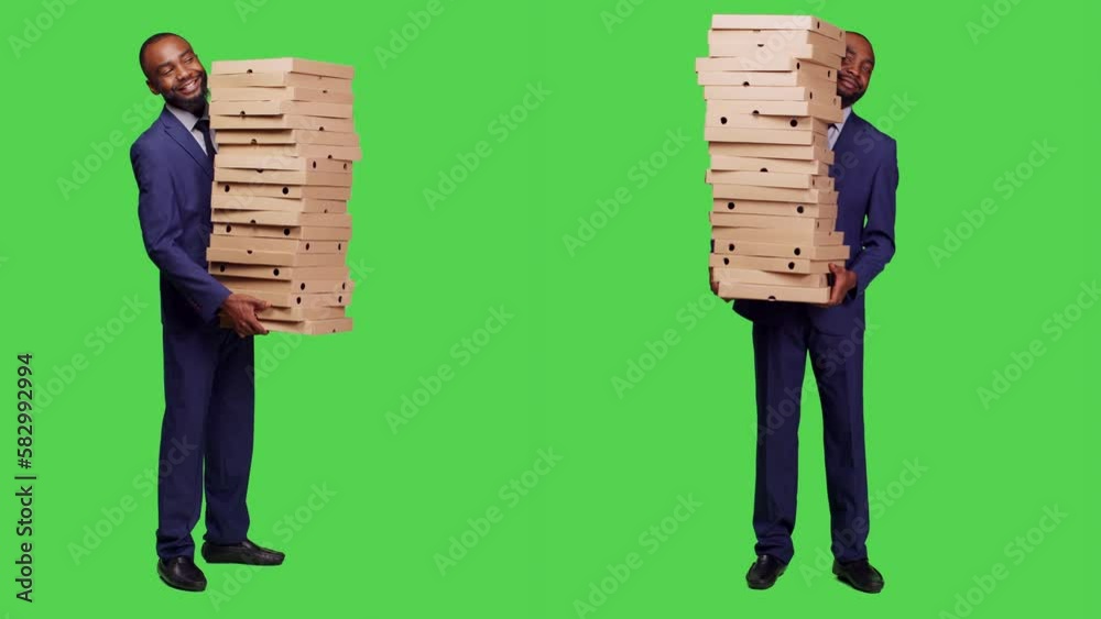 Male entrepreneur holding big pile of pizza boxes on camera, carrying ...