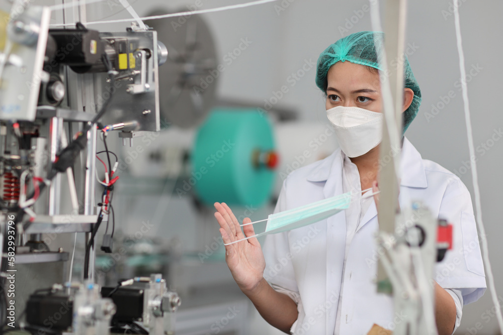 Worker woman in personal protective equipment or PPE inspecting quality ...
