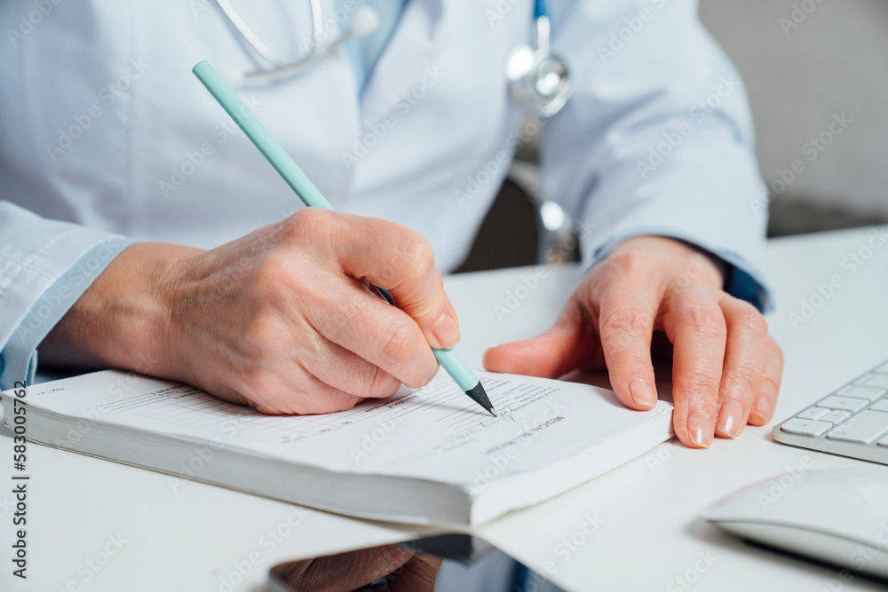 Doctor writing prescription with pen at desk Stock Photo | Adobe Stock