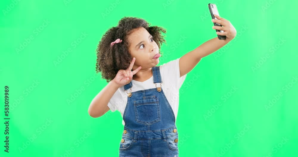Silly little girl, selfie and peace sign on green screen with goofy facial expressions against a ...