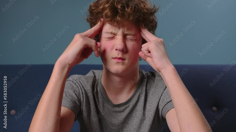 Young depressive boy is sitting and crying about the pain with his head ...