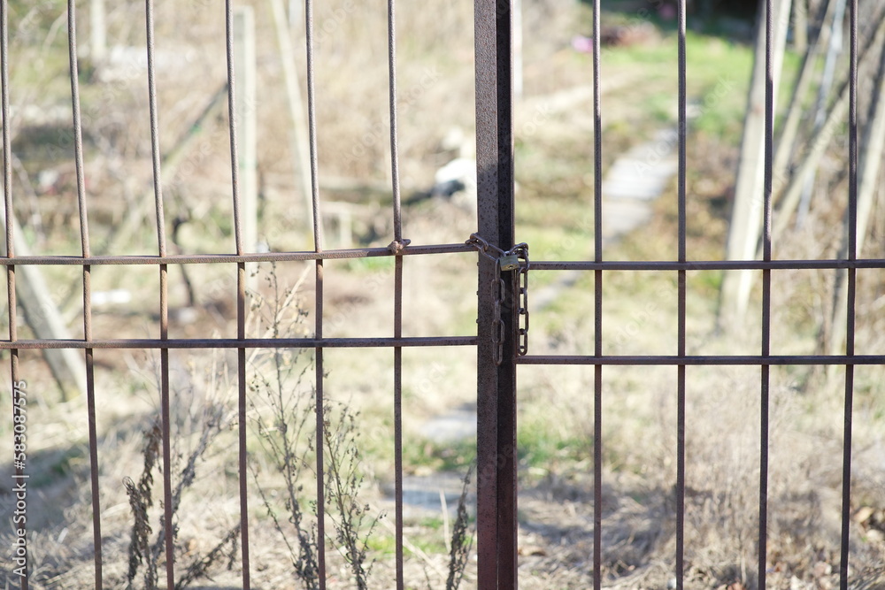 Rusty gate with a locker. The gate appears old and weathered, with a ...