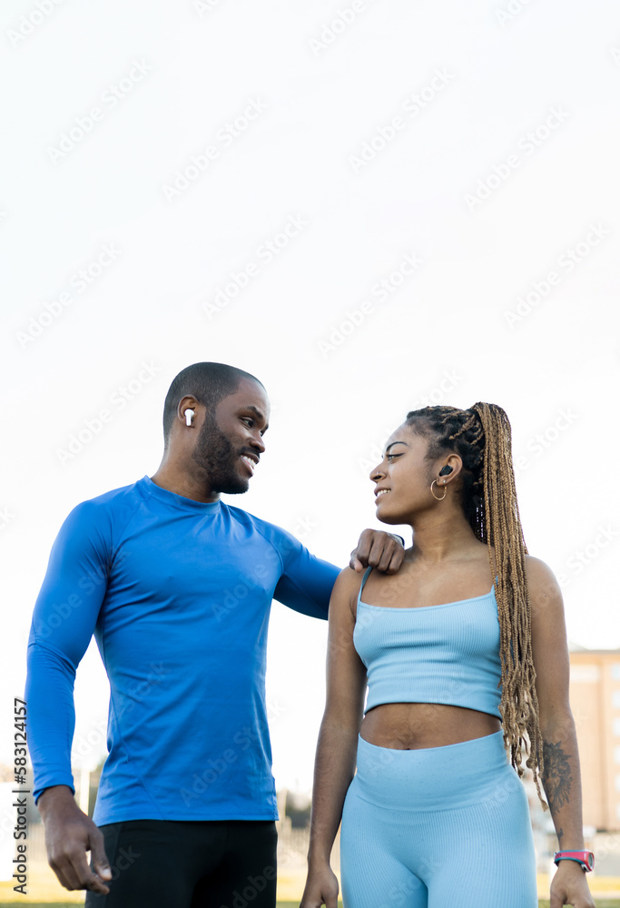 Vertical photo of a dark-skinned couple doing outdoor sports together ...