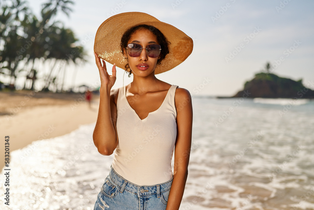 Foto de Young african female model in straw hat and sunglasses posing ...