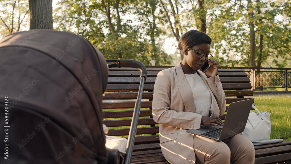 Modern mother working on laptop while baby is sleeping in a stroller in ...