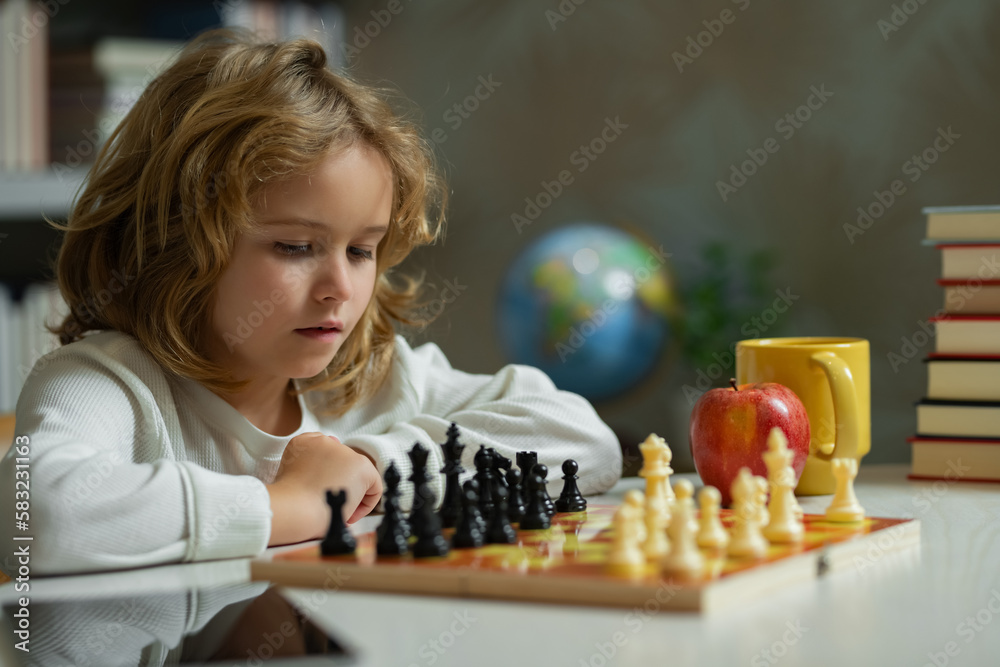 Foto de Little kid play chess in school class. Child boy playing board ...
