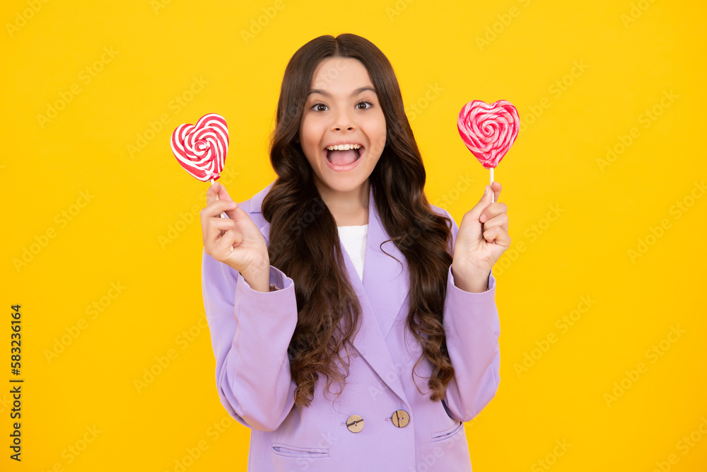 Cool teen child with lollipop over yellow isolated background. Sweet ...