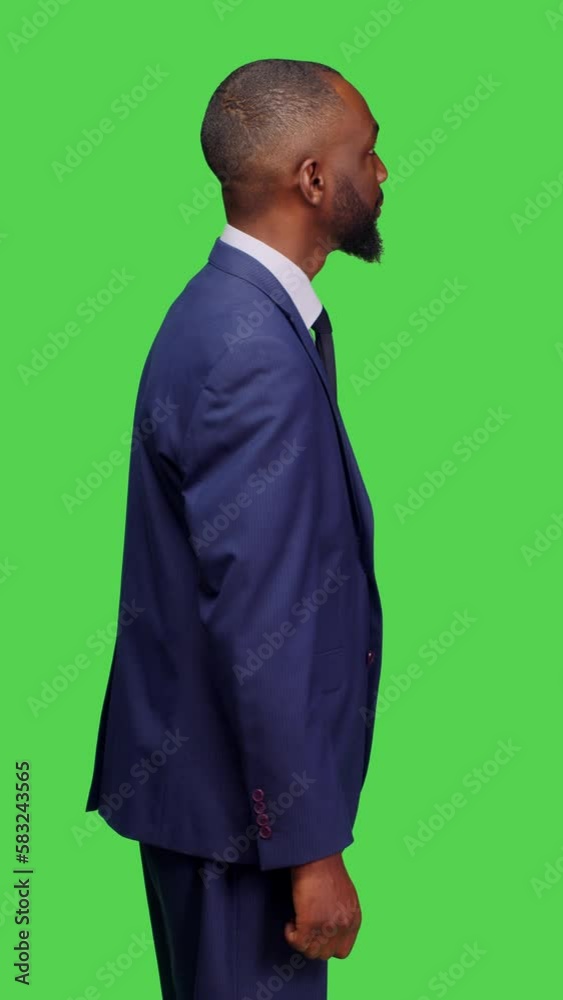 Vertical video: Profile of optimistic adult standing over green screen ...