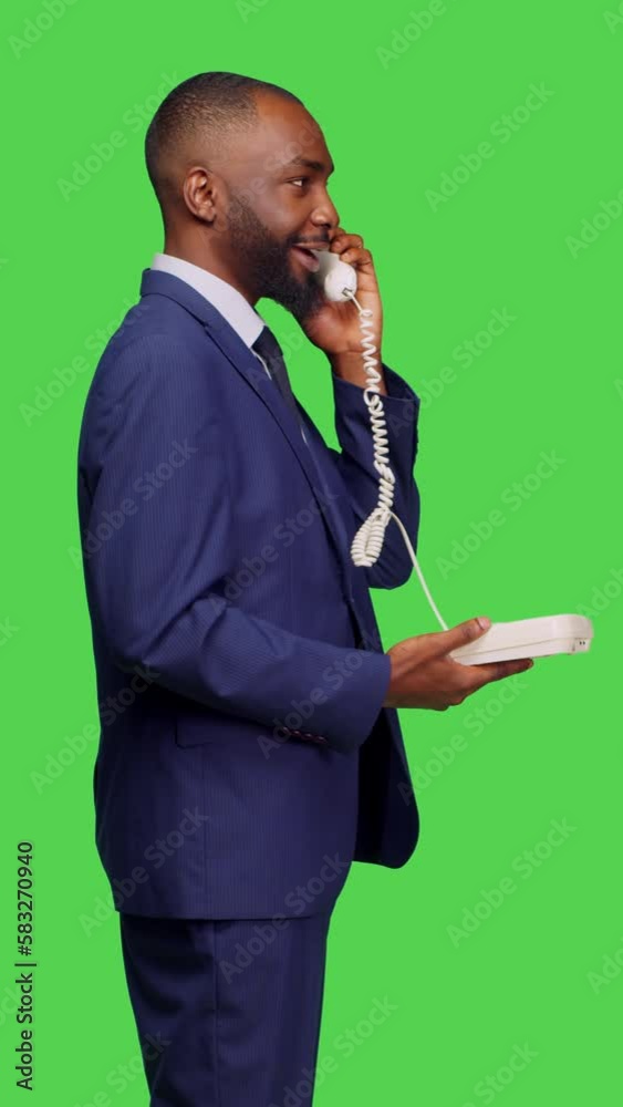 Vertical video: Profile of african american man using landline phone to ...