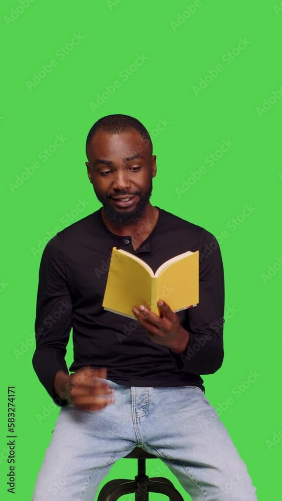 Vertical video: Front view of confident adult holding book to read ...