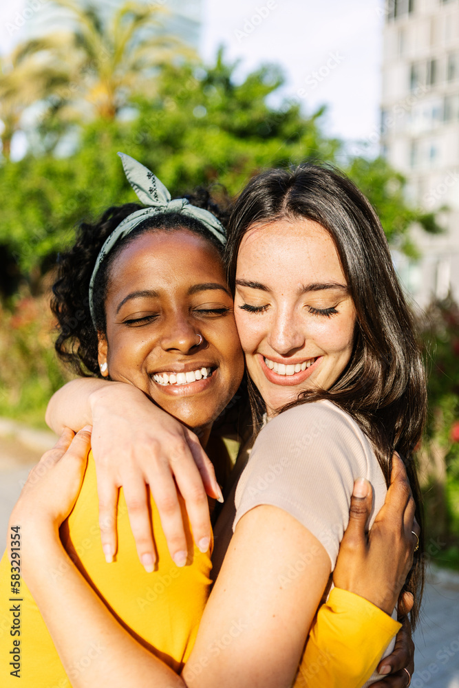 Vertical portrait of candid happy multiracial best women friends ...