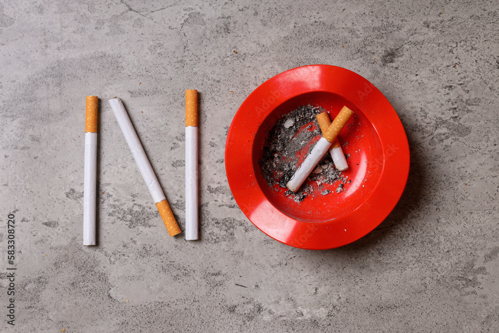 No Smoking sign made with cigarettes and red ashtray on rustic grey ...