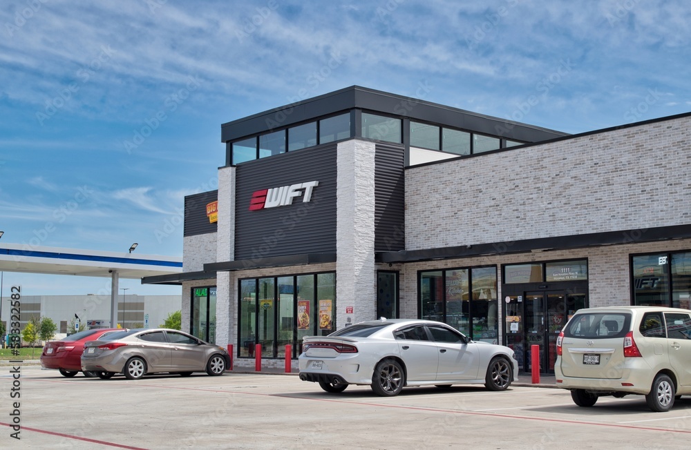 Swift gas station and convenience store storefront exterior with parked ...