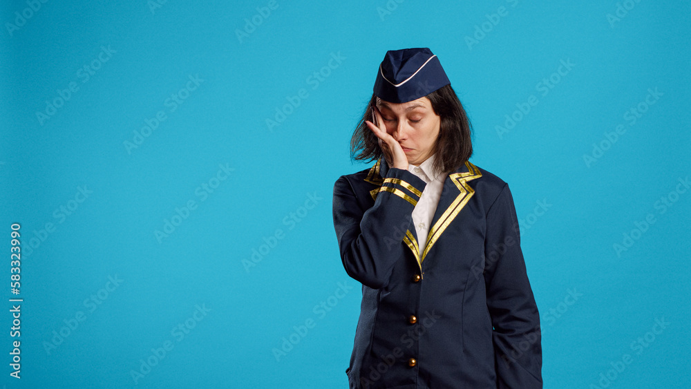 Air hostess feeling tired and yawning in studio, being drained and worn ...