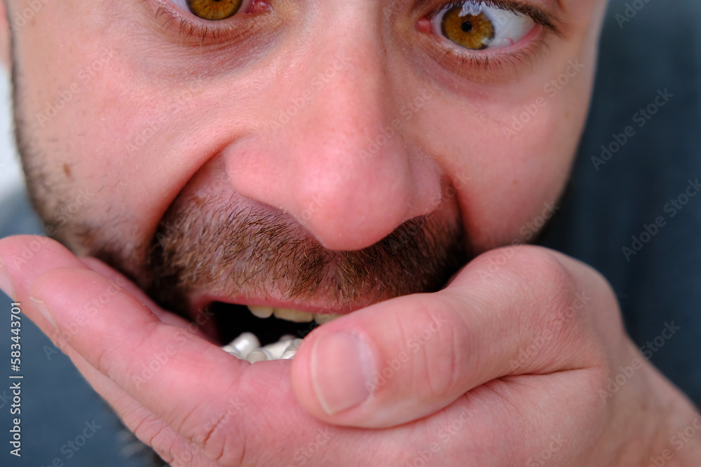 male wide open mouth eating pills, vitamins, capsule from palm, young ...