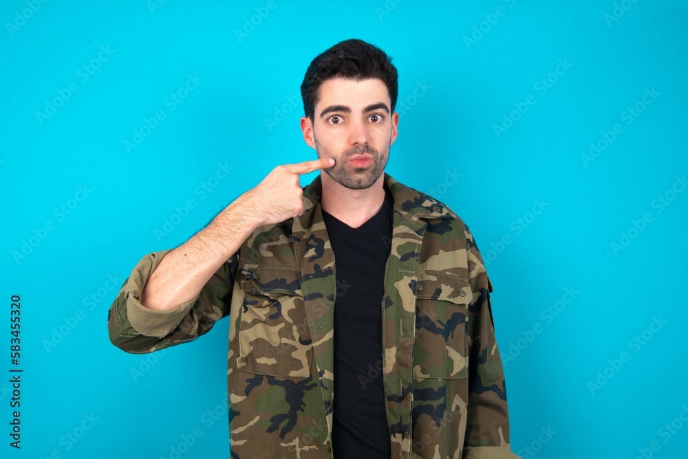 Charming Young man standing over blue studio background pointing on ...