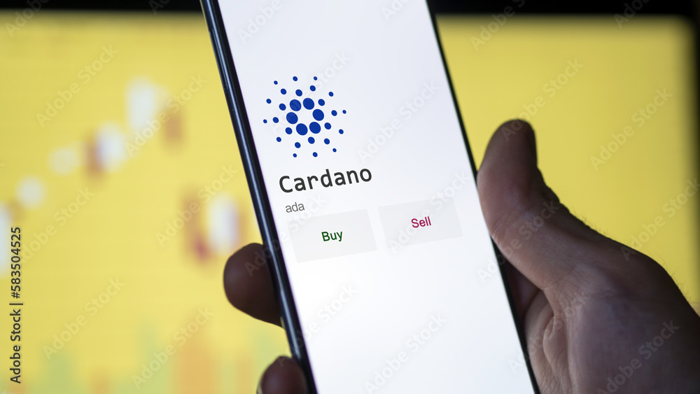 $ADA An investor's analyzing the cardano coin on screen. A phone shows ...