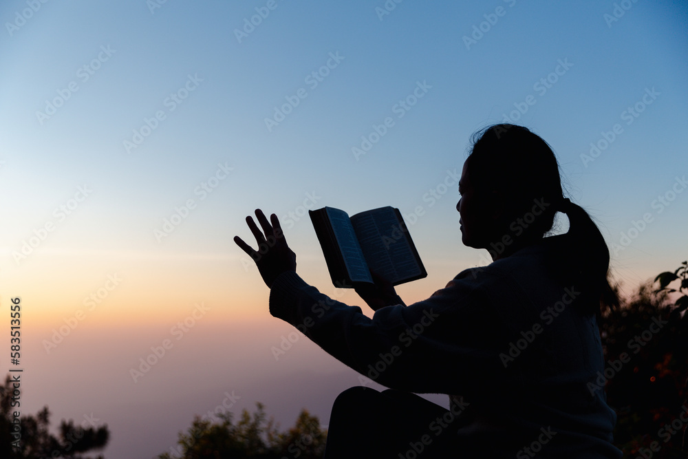 Silhouette of woman kneeling down praying for worship God at sky ...