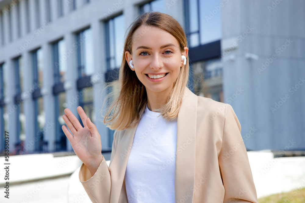Portrait of the smiling positive caucasian woman standing waving hello ...