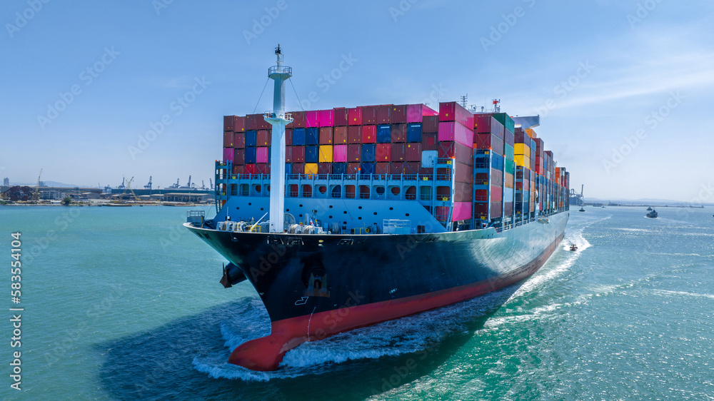 Aerial in front view of cargo ship carrying container and running for ...