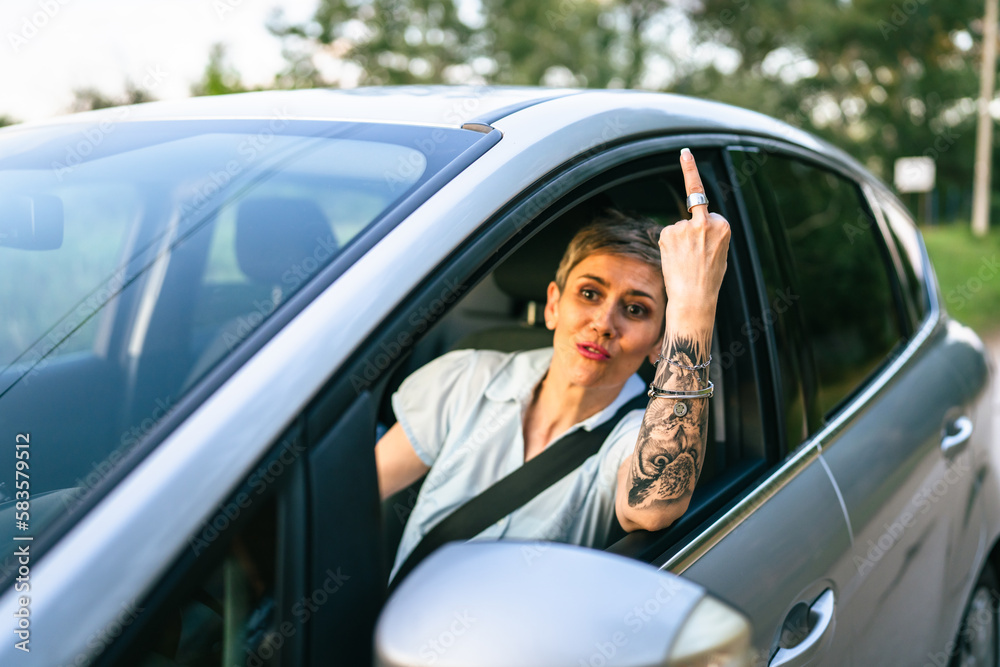 Foto Stock woman senior mature driver show middle finger trough the ...