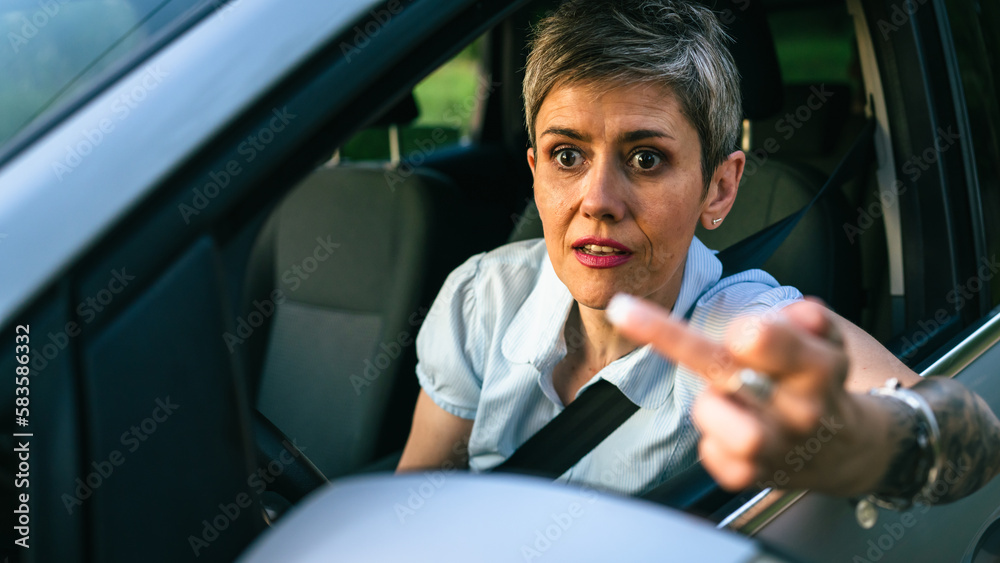 woman senior mature driver show middle finger trough the window of car ...