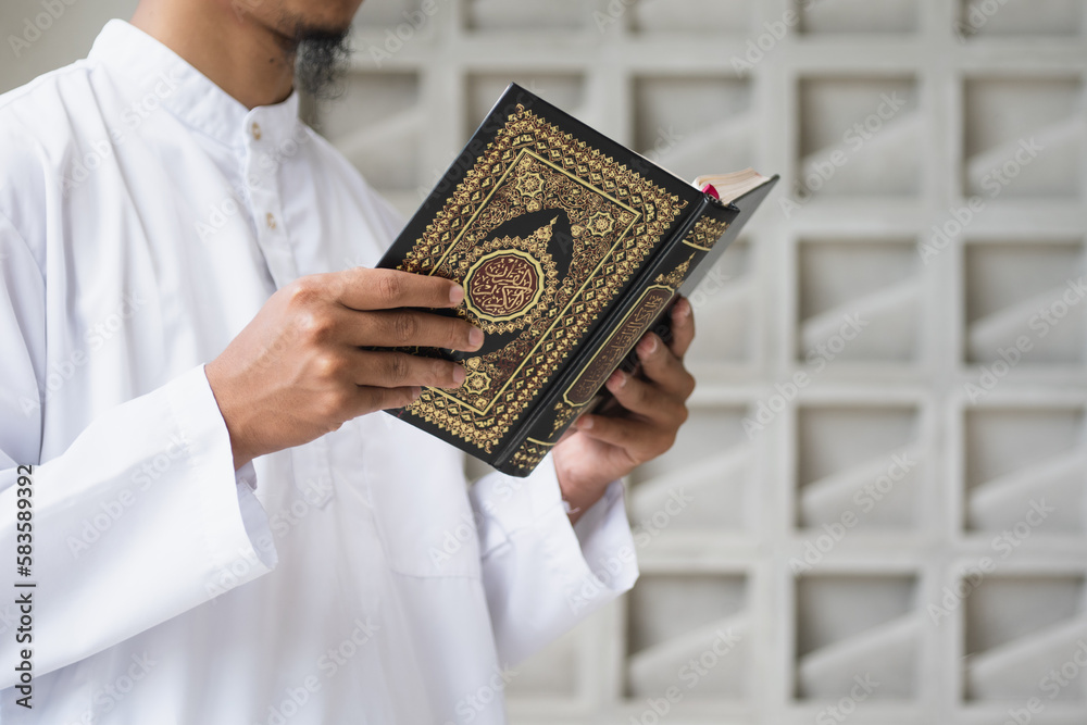 Muslim man reading holy Quran. Holy Quran in Hand with arabic text ...