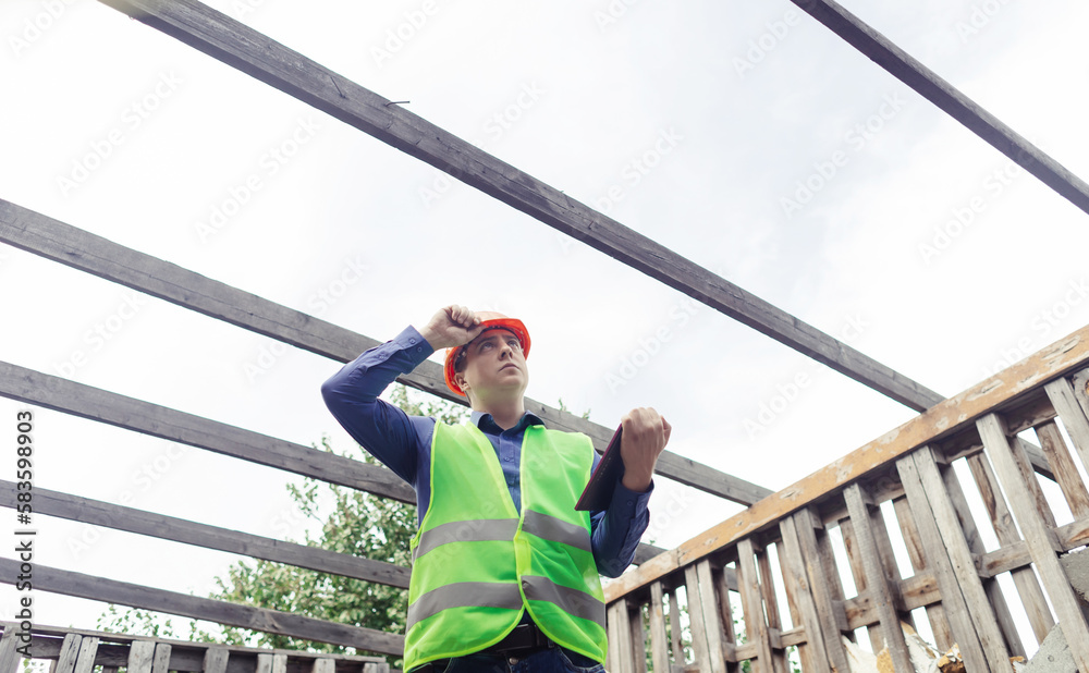 Building inspector. Man in a hard hat and a yellow reflective vest ...