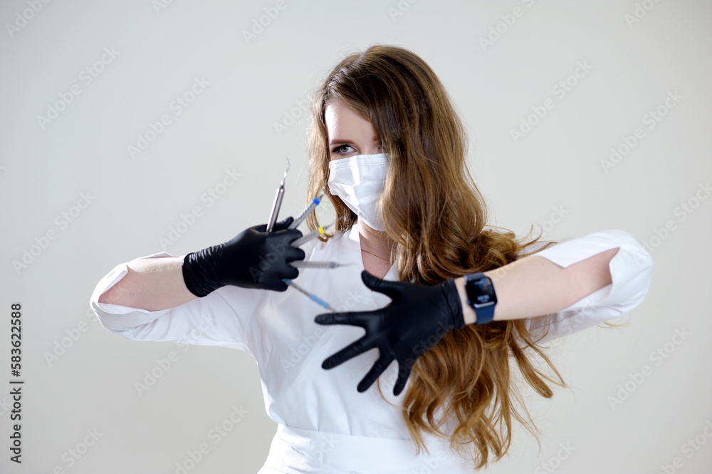 Surgeon holds scalpel dressed in surgical apron and mask light ...