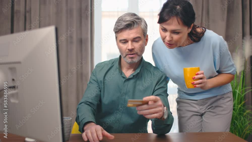 Zooming out Caucasian family doing online shopping. Handsome husband using computer and bank ...