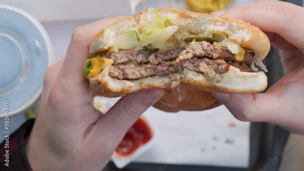 Man holding bitten burger in hands. Male eating hamburger in fast food ...