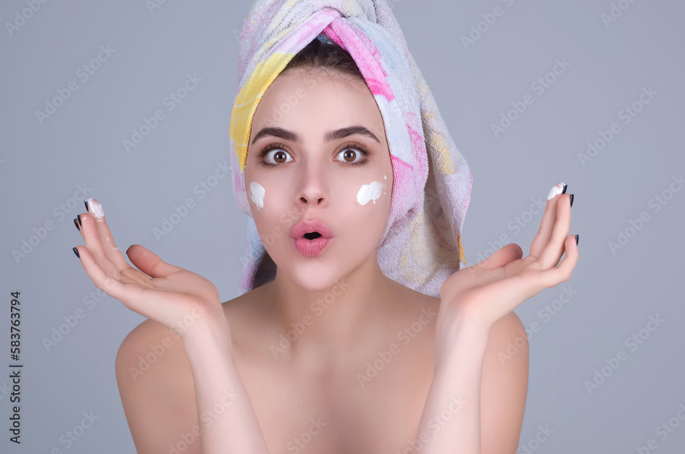 Skin care. Beauty portrait of a beautiful woman applying face cream ...