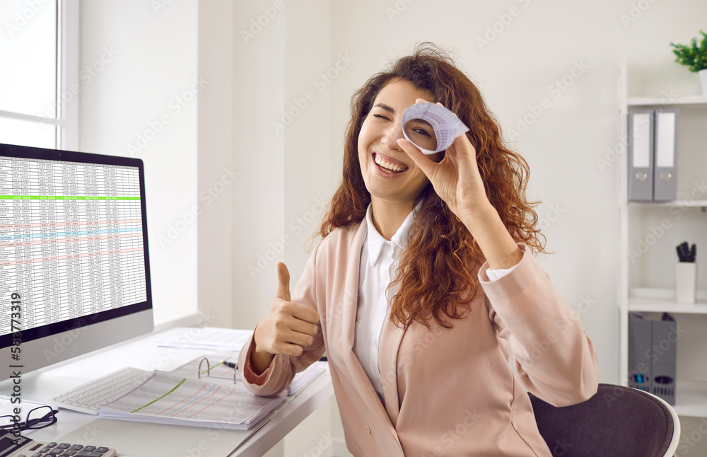 Smiling businesswoman looking through rolled up sheet of paper. Smiling ...